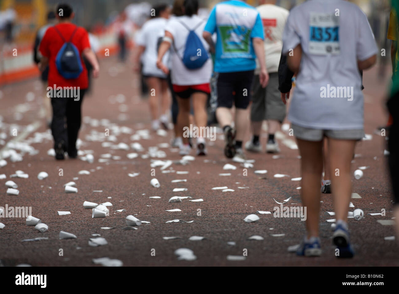 competitors walking home through discarded polystyrene cups litter ...