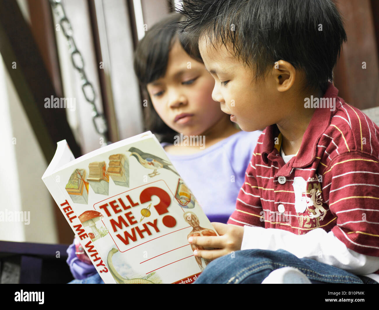 Young sister reading book with brother Stock Photo - Alamy