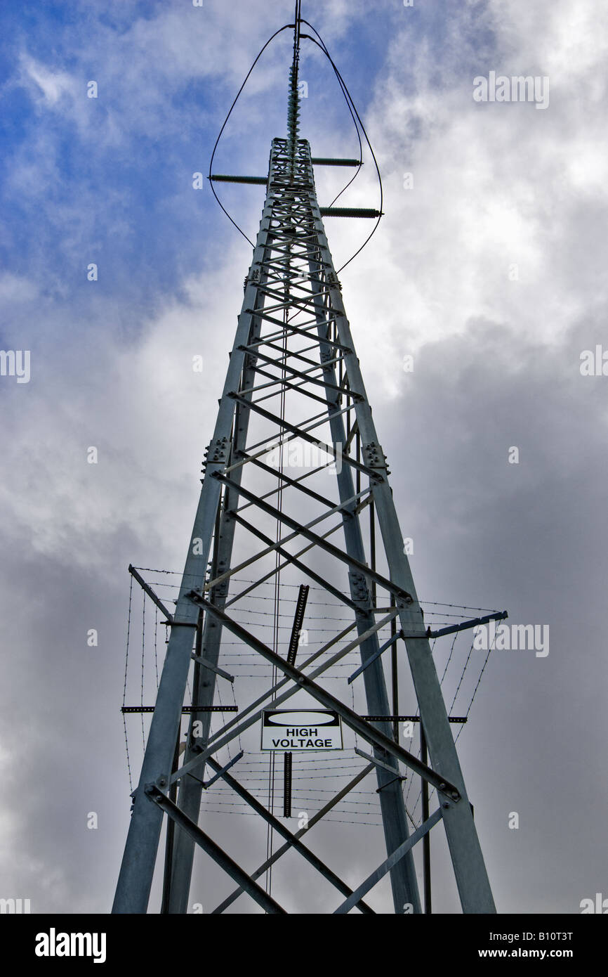 An electricity pylon with barbed wire above the High Voltage sign Stock ...