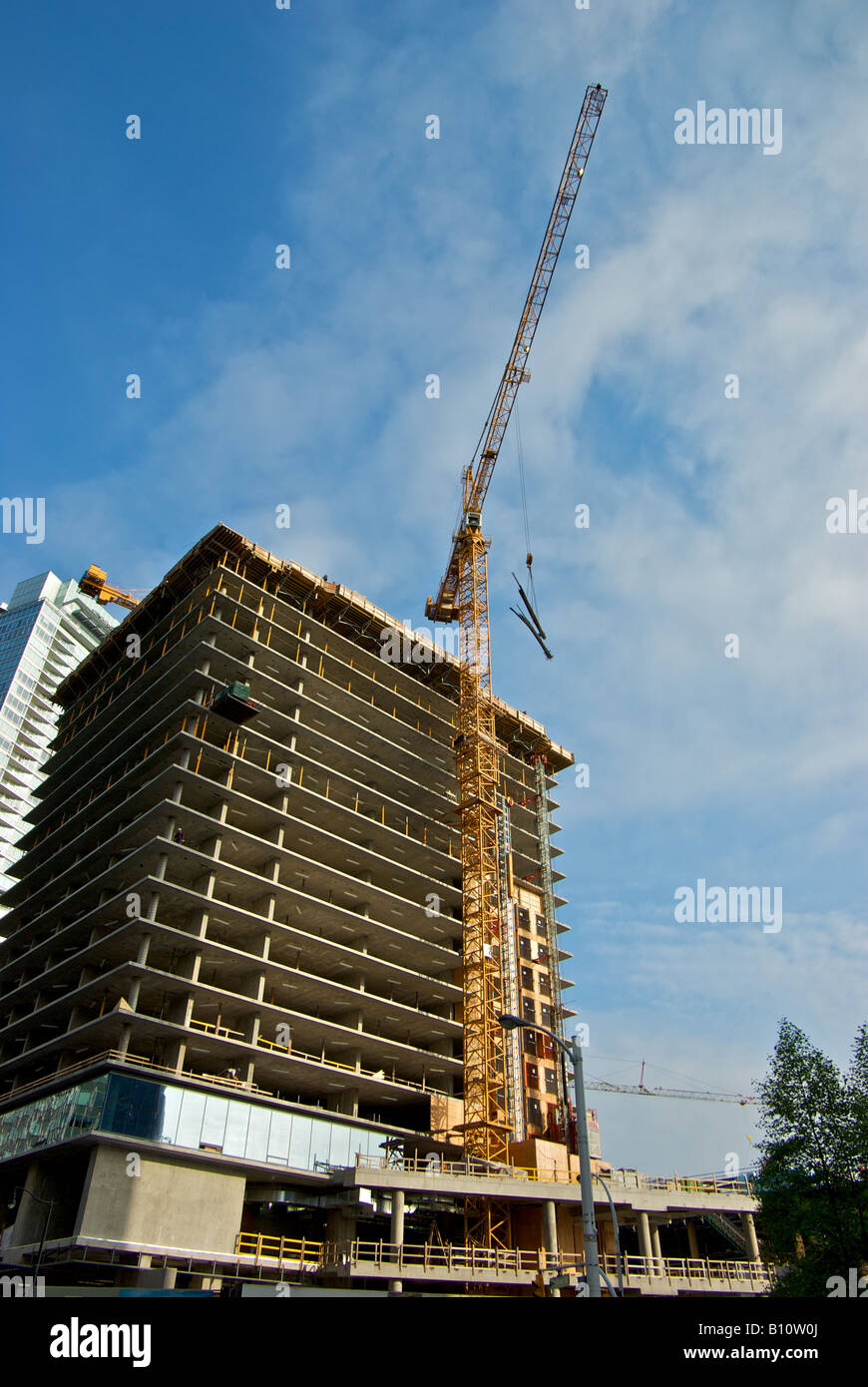 Sky crane bringing reinforcing steel to the top of a building under ...