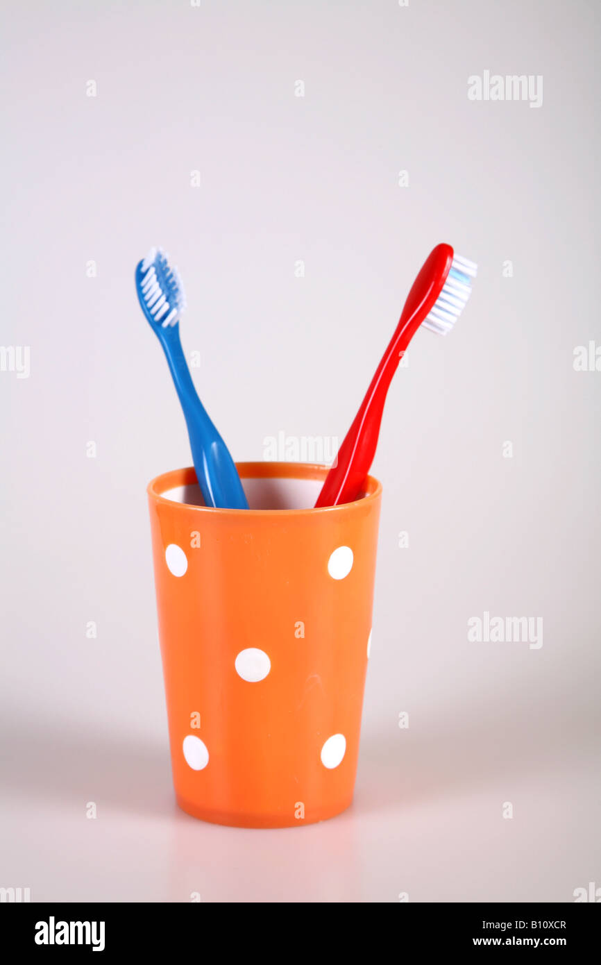 Toothbrush red and blue in a spotted holder Stock Photo - Alamy