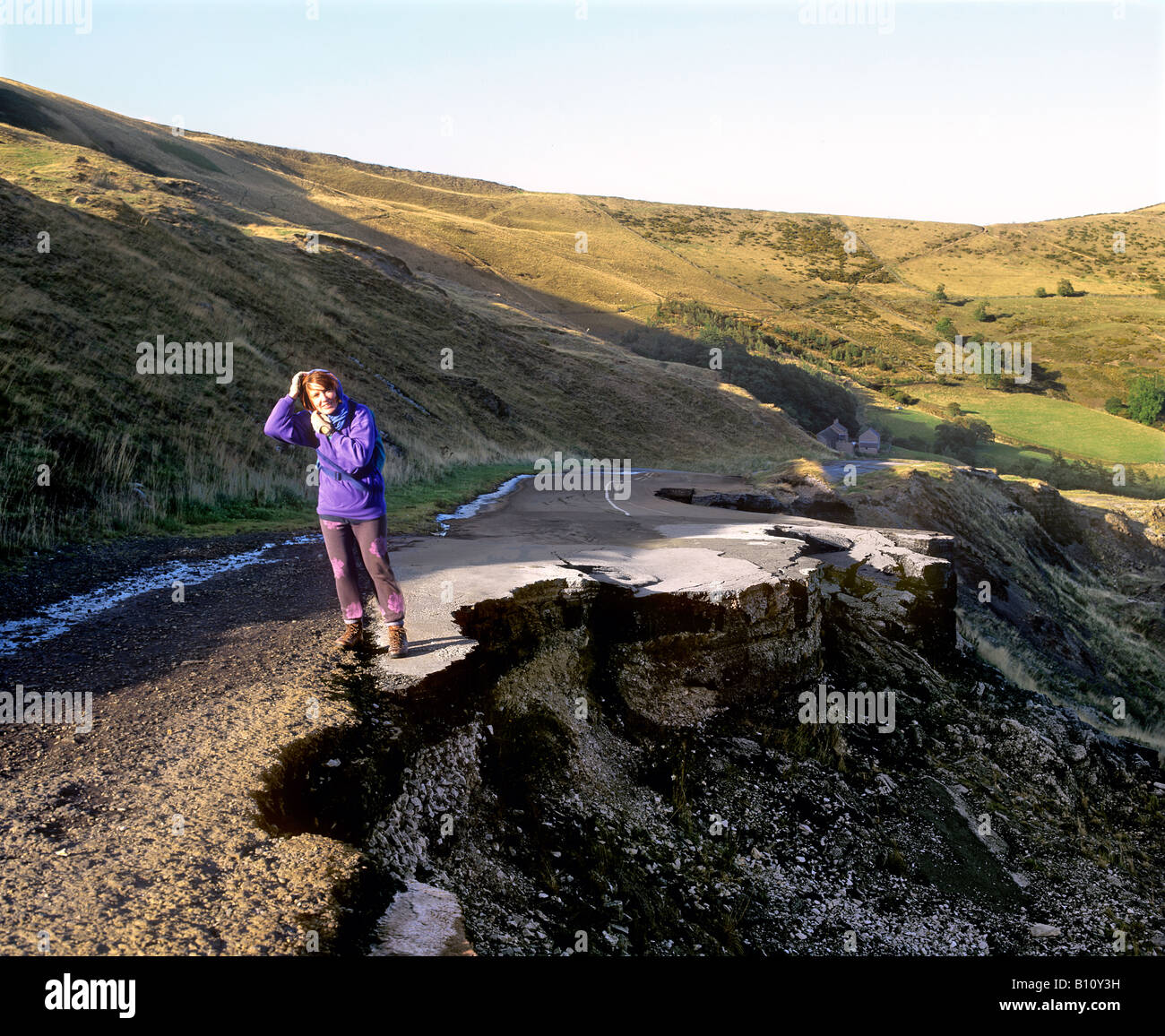 A walker passing a landslip on the old road around Mam Tor, near ...