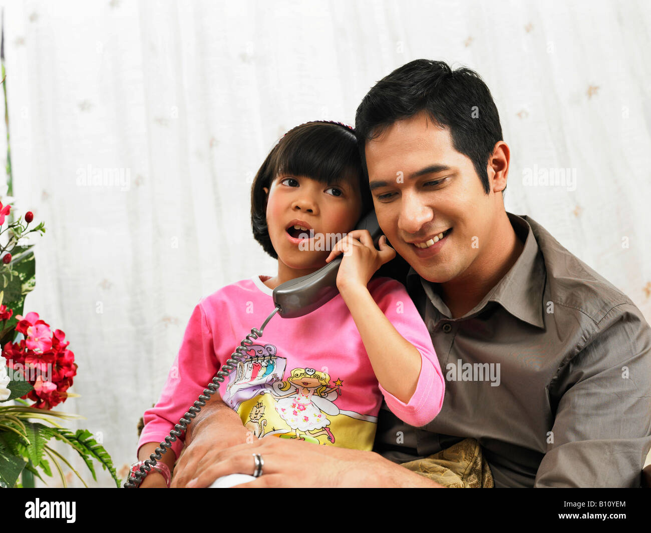 Daughter talking on the phone, father listening Stock Photo - Alamy