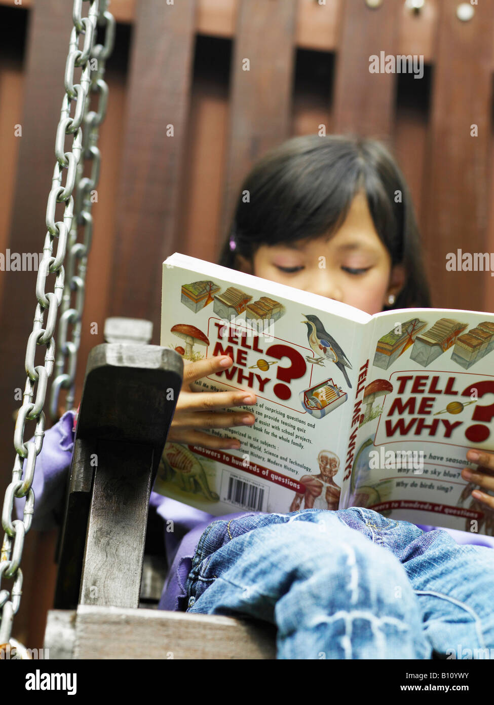 Girl on a swing, reading Stock Photo - Alamy