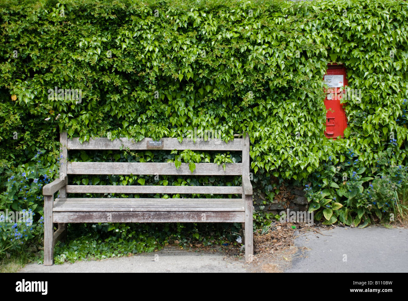 gpo red post box and village seat Stock Photo - Alamy