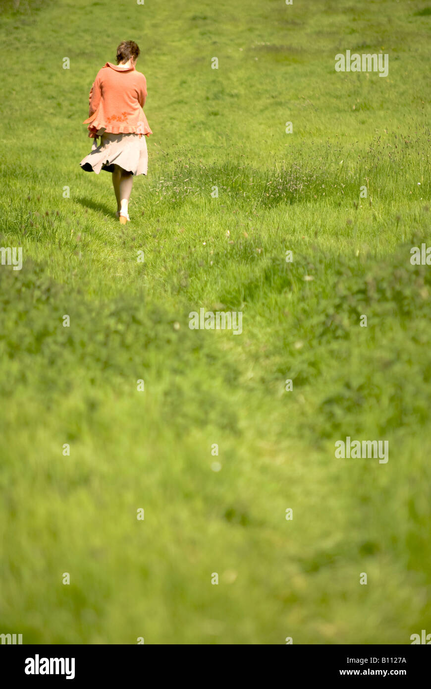 woman walking through meadow Stock Photo - Alamy