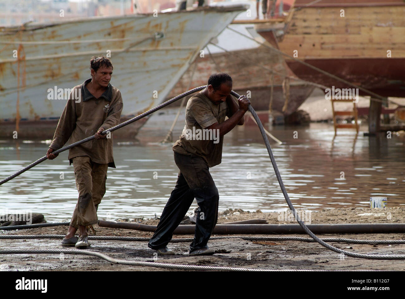 Dock workers pulling a rope Stock Photo - Alamy