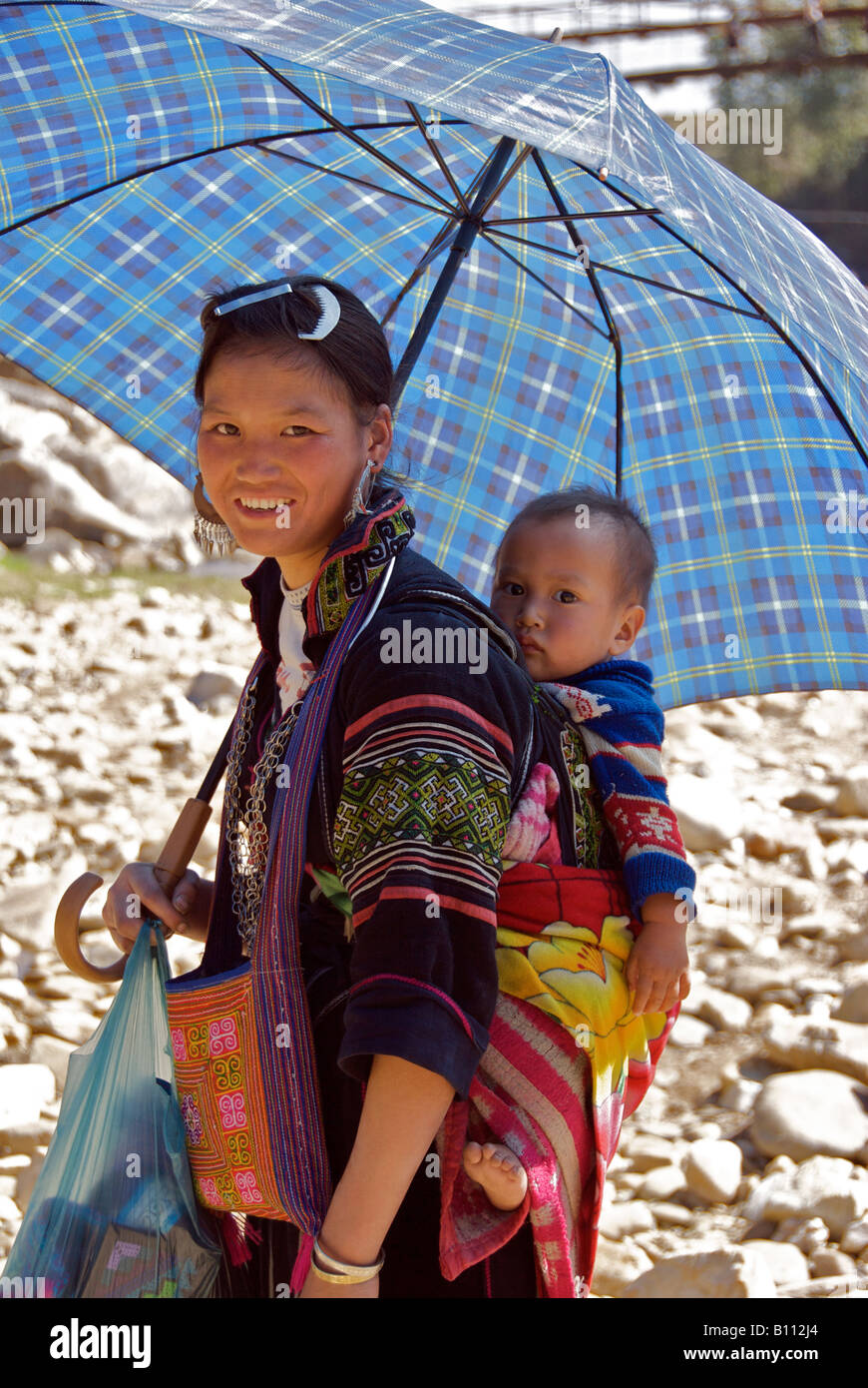 Black Hmong woman carrying baby and umbrella near Sapa Northern Vietnam ...