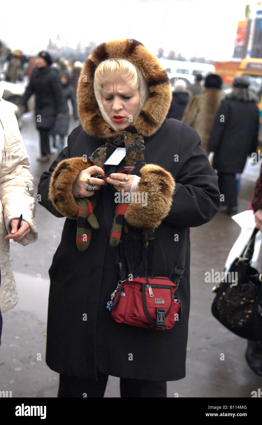 A woman dressed to keep warm in the bitter cold winter weather checks ...