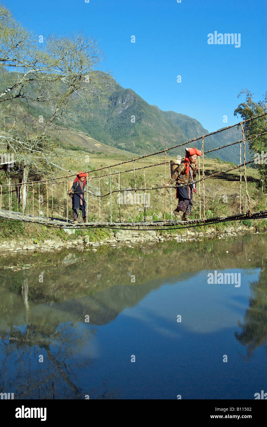 Two Red Dzao women crossing rope bridge Cat Cat Valley near Sapa ...