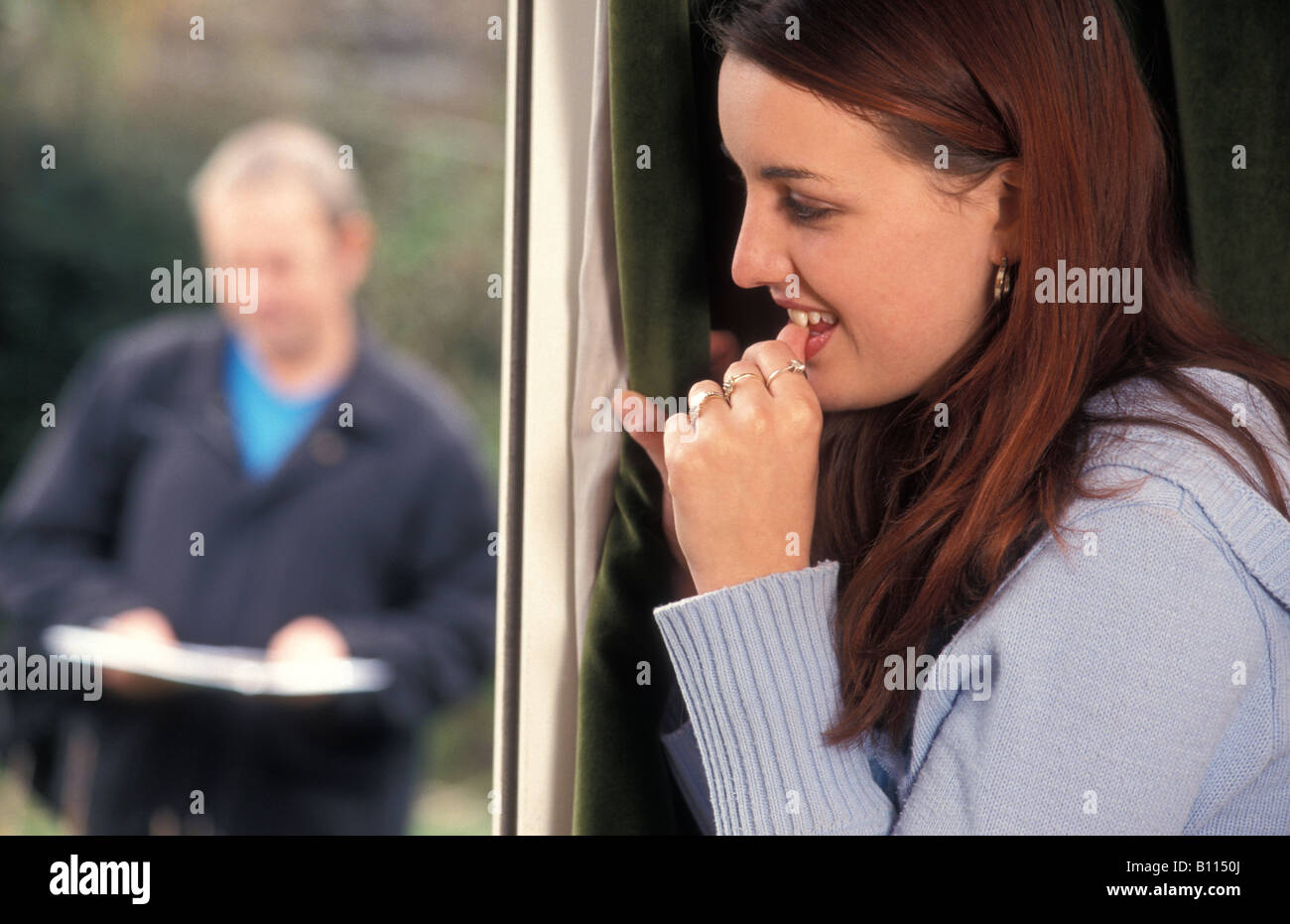 nervous teenage girl waiting by door as male arrives with post Stock ...