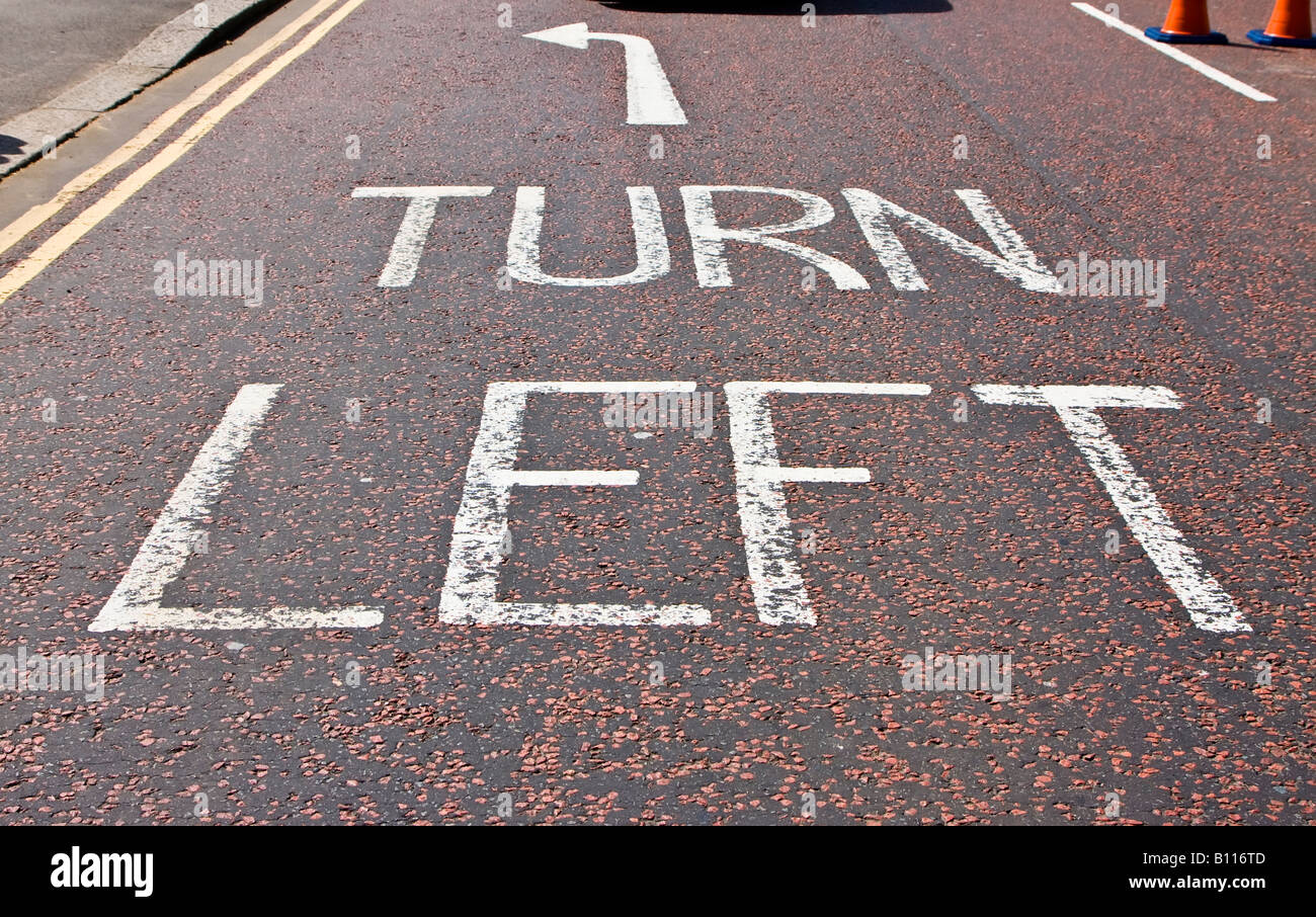 Turn left sign in typical London street asphalt Stock Photo - Alamy