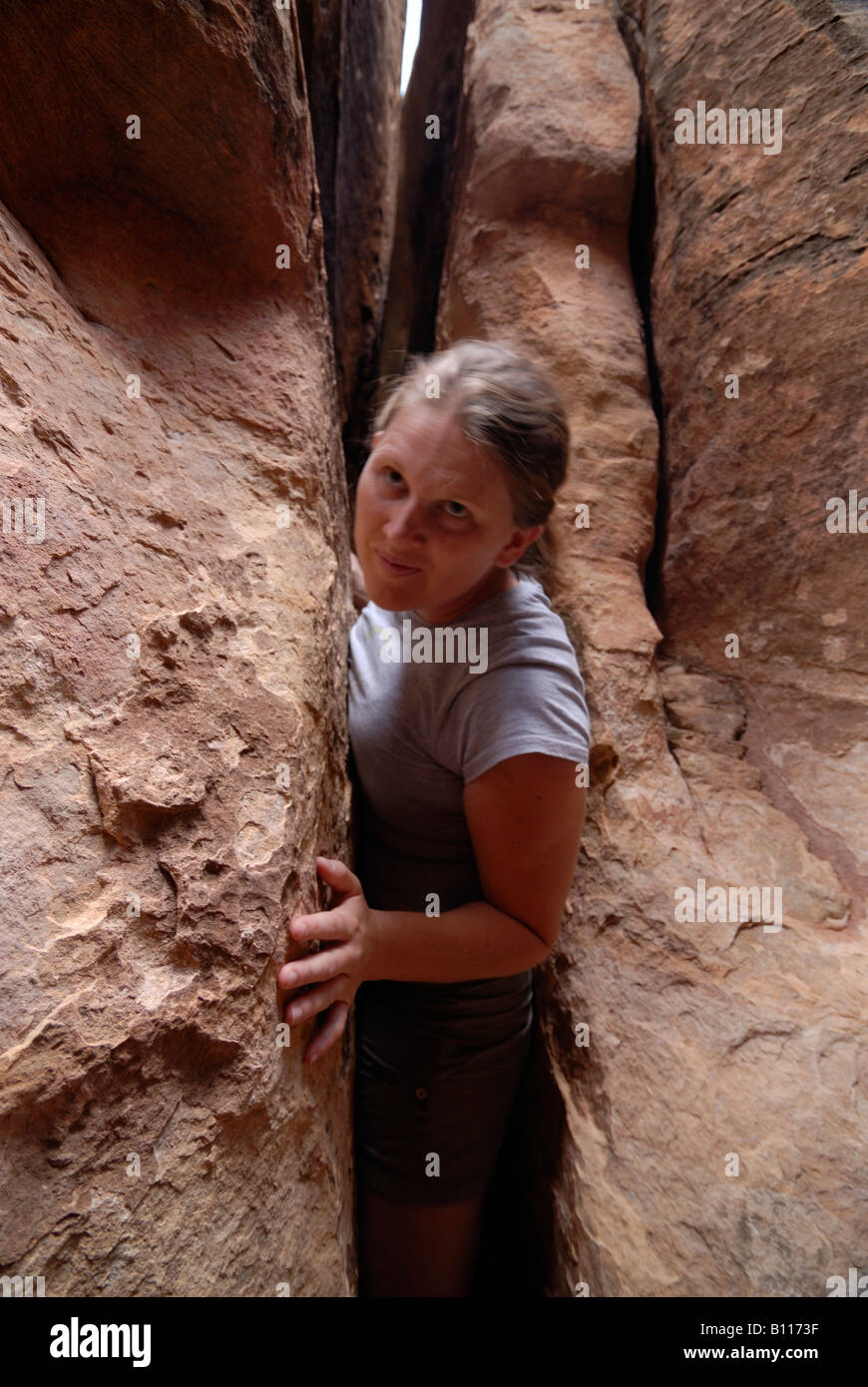 Tourist squeezing through a granite rock split in The Needles ...