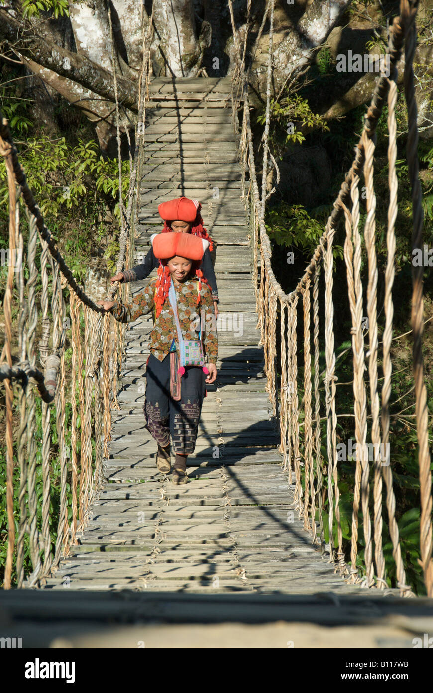 Two Red Dzao women crossing rope bridge Cat Cat Valley near Sapa ...
