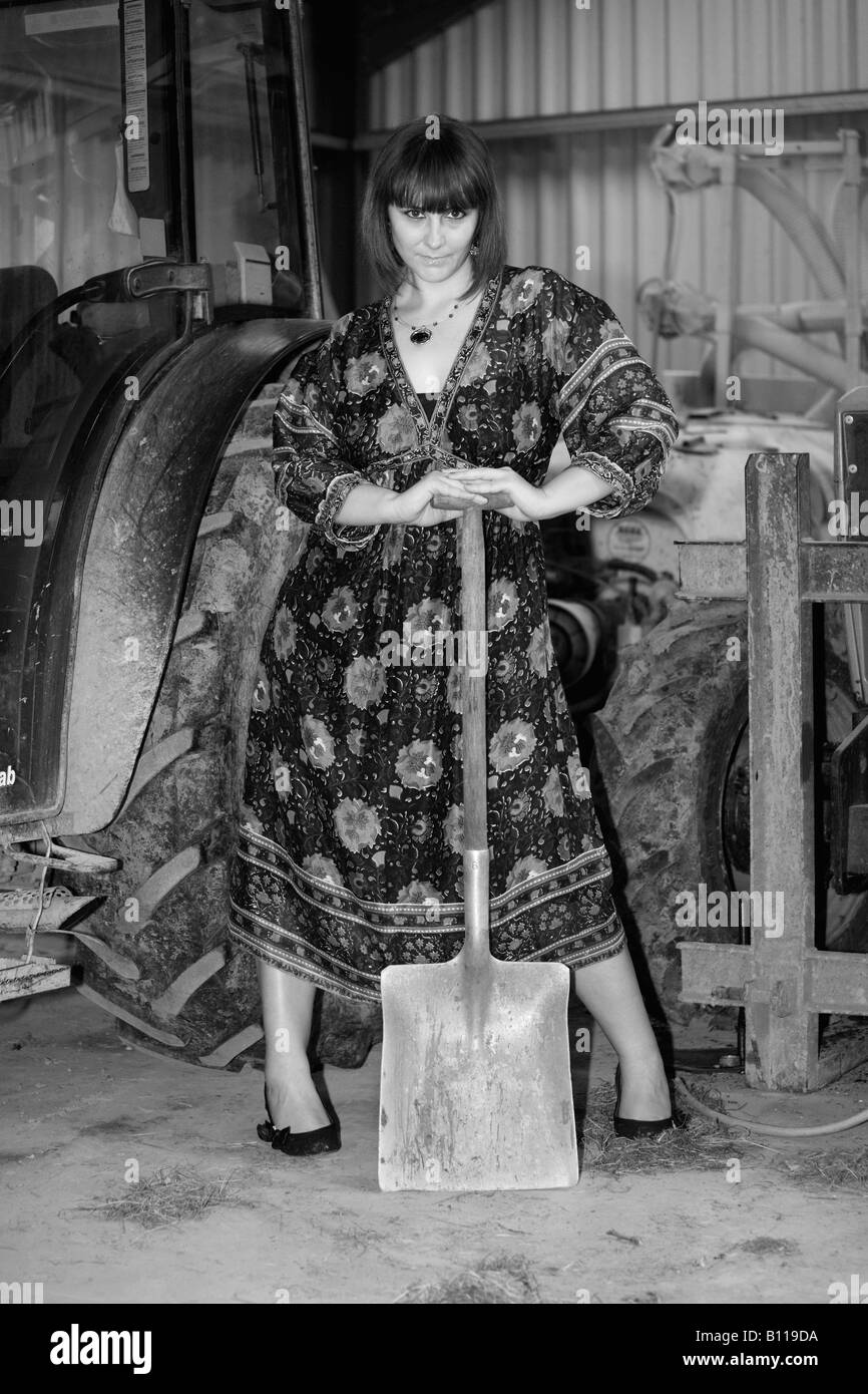 A female in a barn with a shovel Stock Photo - Alamy