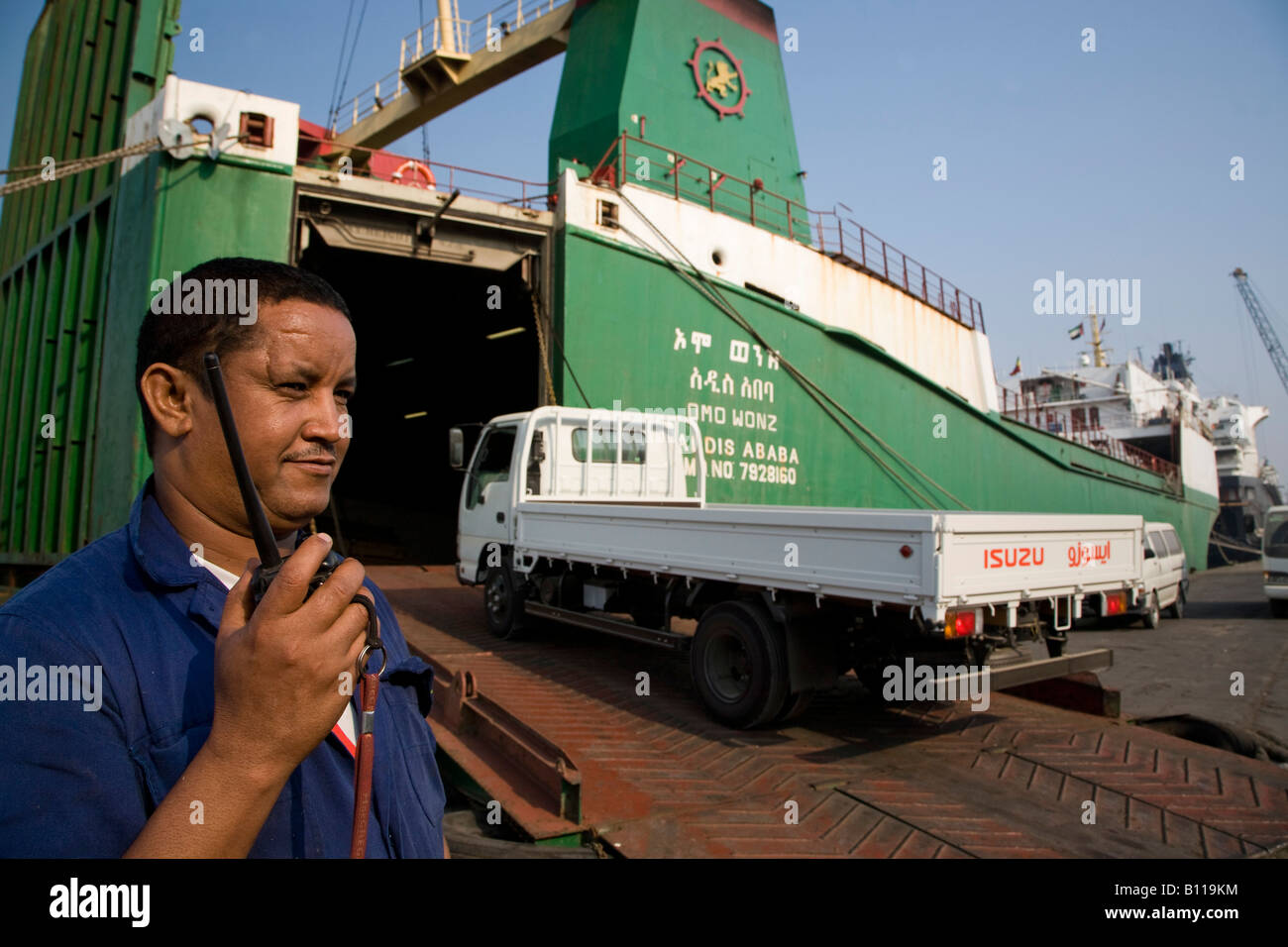 Stevedore overseeing loading operations as lorries are loaded onto a ...