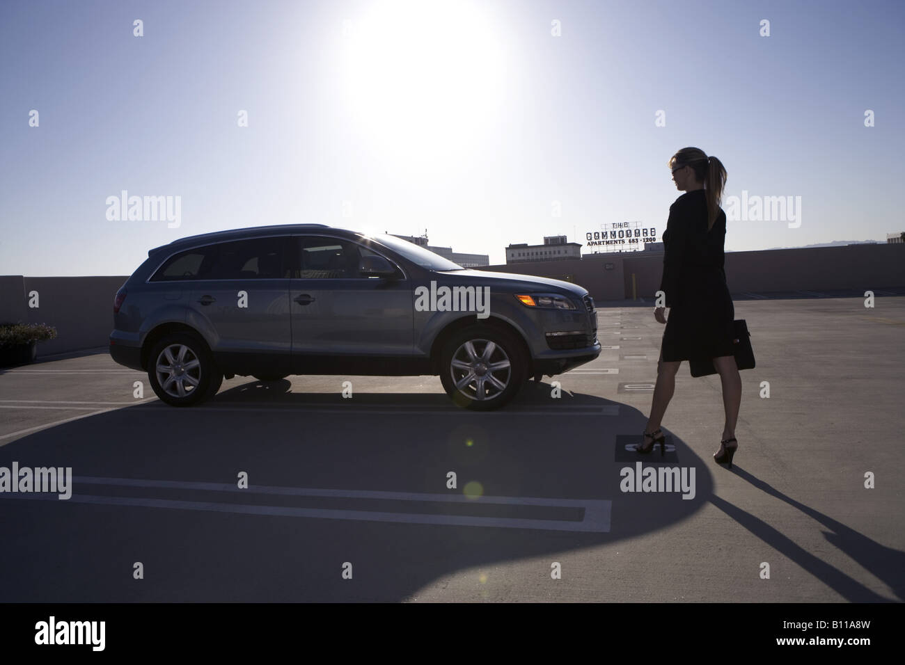 Woman with SUV on rooftop of parking garage Stock Photo - Alamy