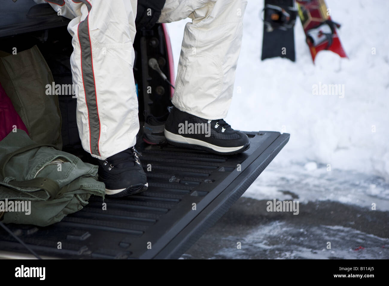 Young mans feet on back of truck on snowy hillside Stock Photo - Alamy