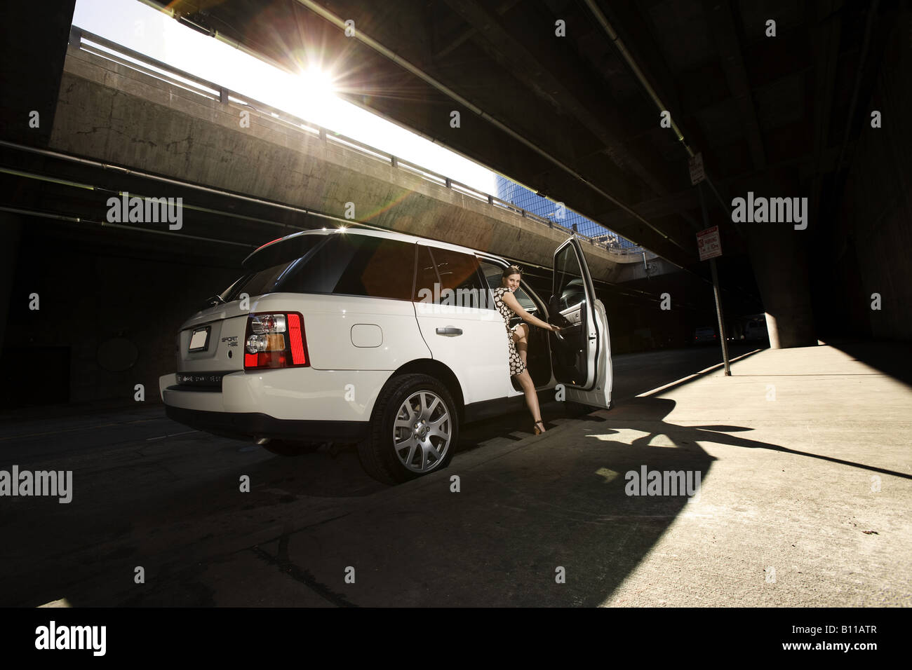 Young woman exiting white car Stock Photo - Alamy