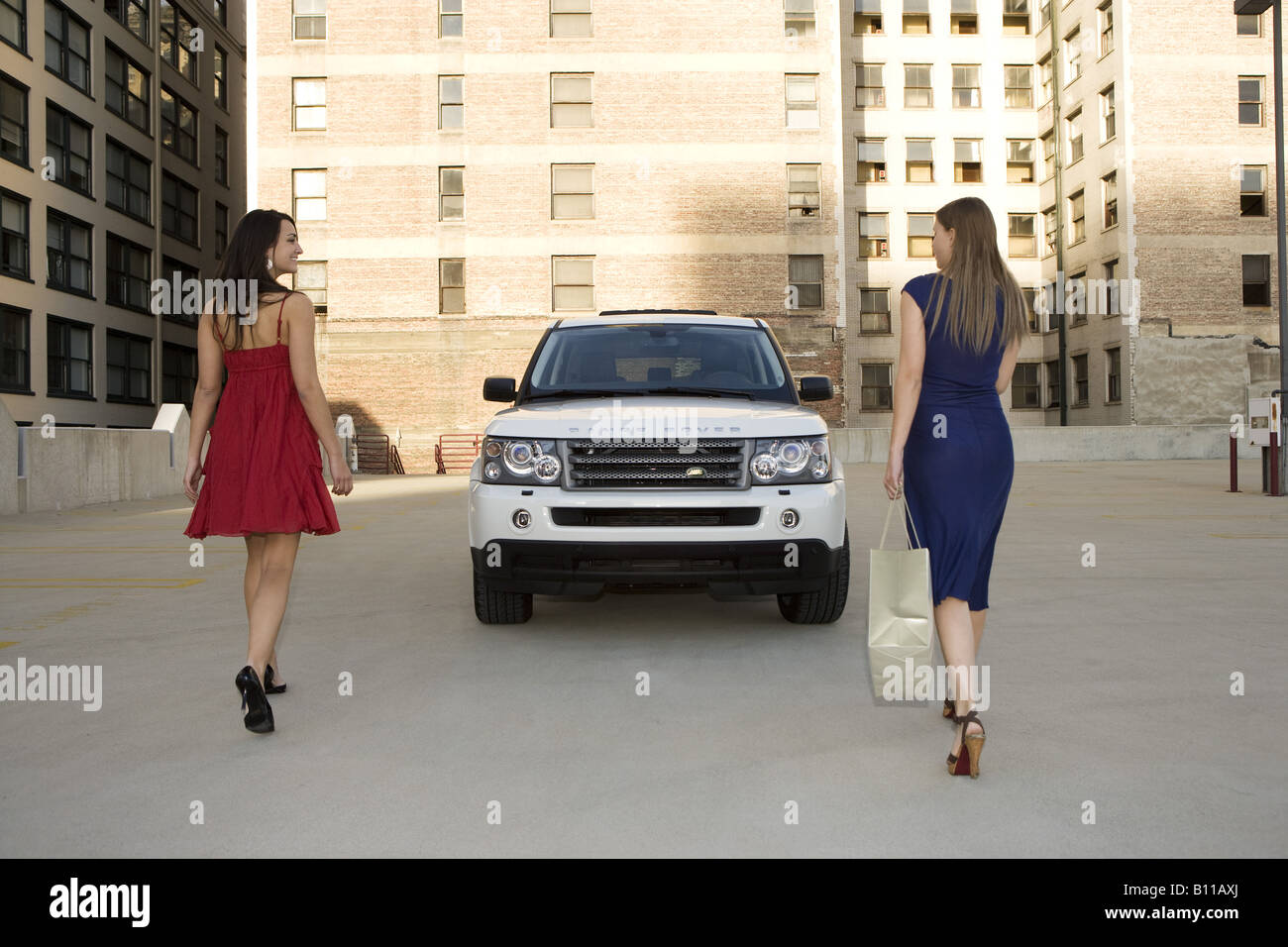 Two young women against front of white Range Rover Sport Stock Photo ...