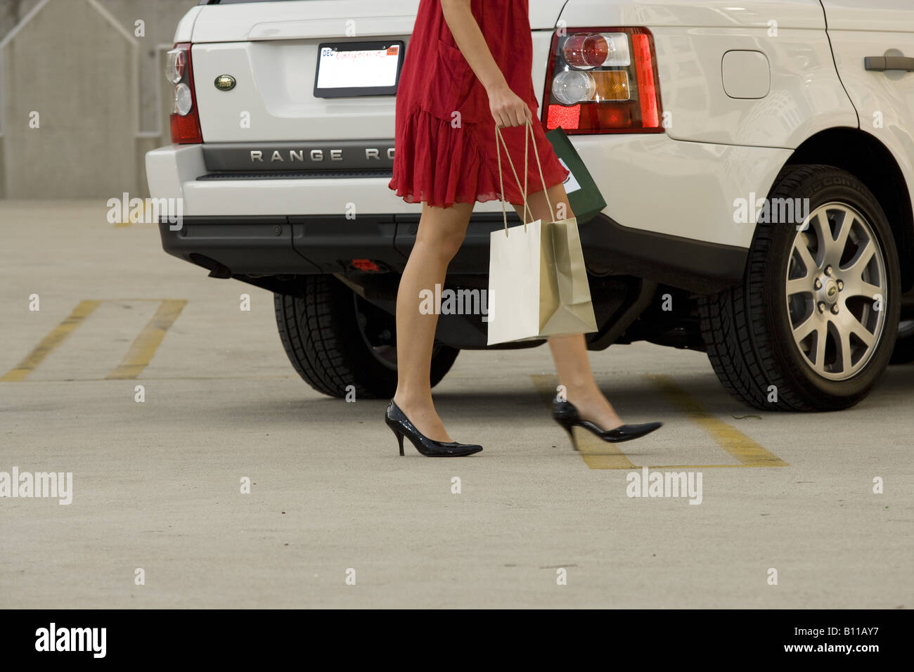 Young woman walking by white Range Rover Sport Stock Photo - Alamy