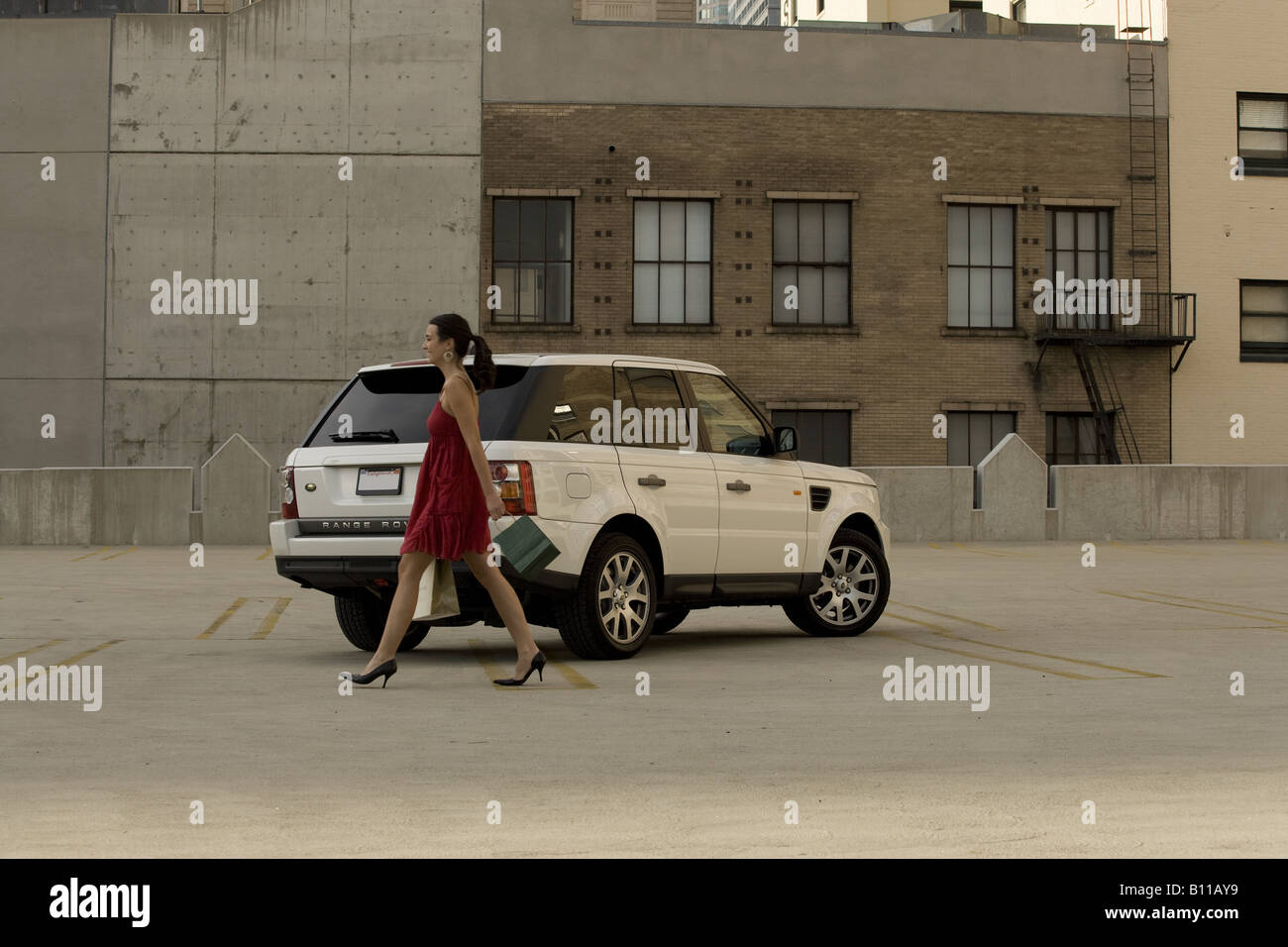 Young woman walking by white Range Rover Sport Stock Photo - Alamy