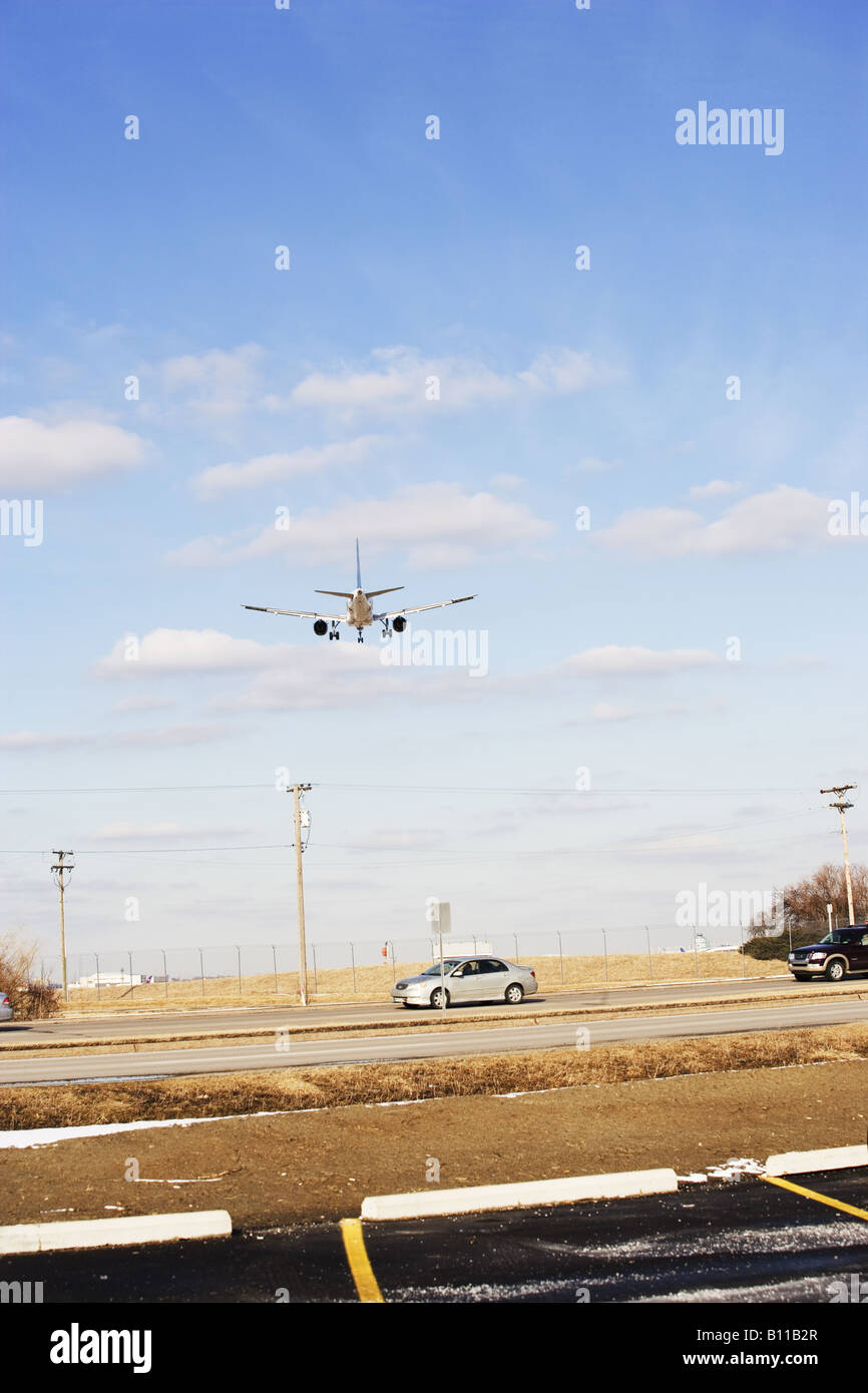 Airplane flying over highway preparing to land at airport Stock Photo ...