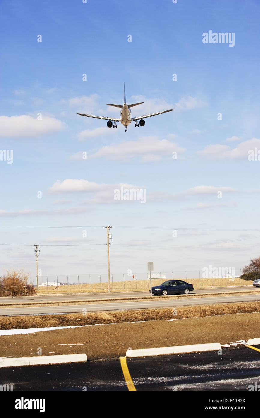 Airplane flying over highway preparing to land at airport Stock Photo ...