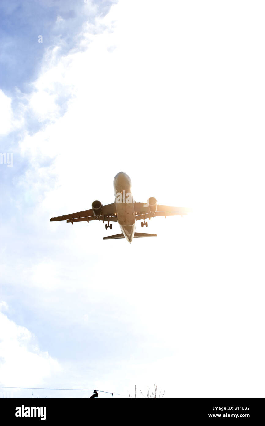 Airplane flying overhead preparing to land at airport Stock Photo - Alamy