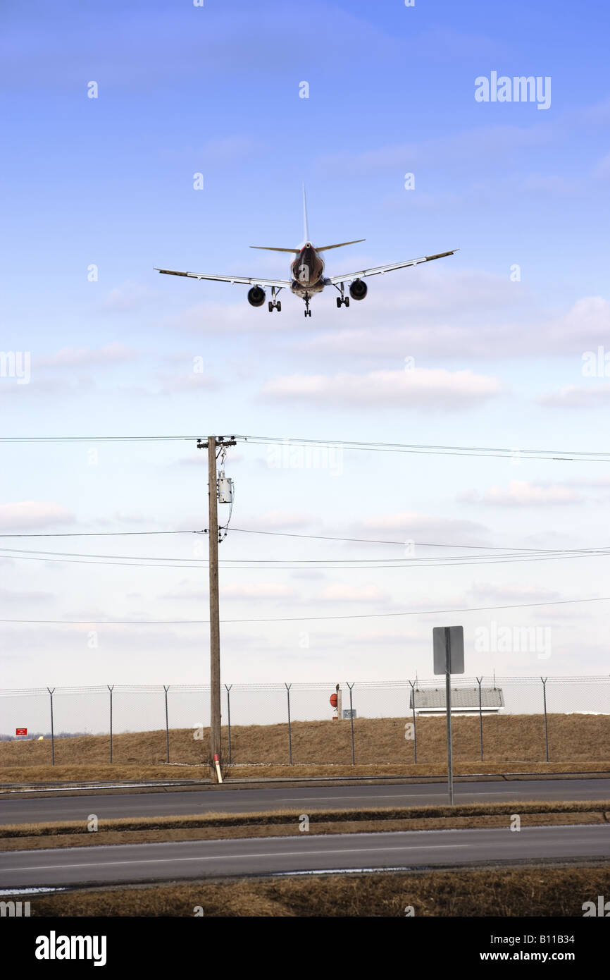 Airplane flying overhead preparing to land at airport Stock Photo - Alamy