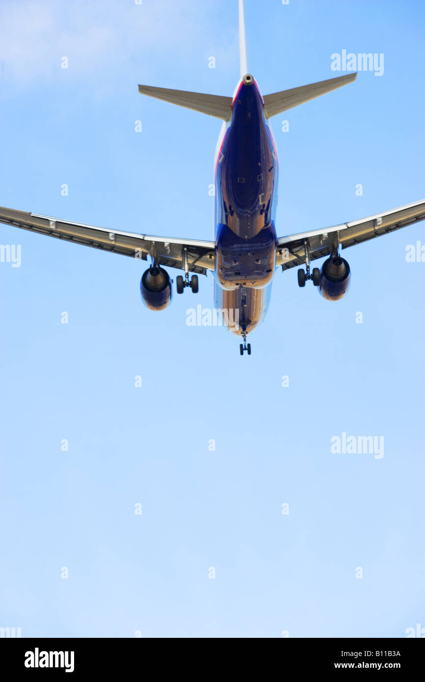 Blue airplane flying overhead Stock Photo - Alamy