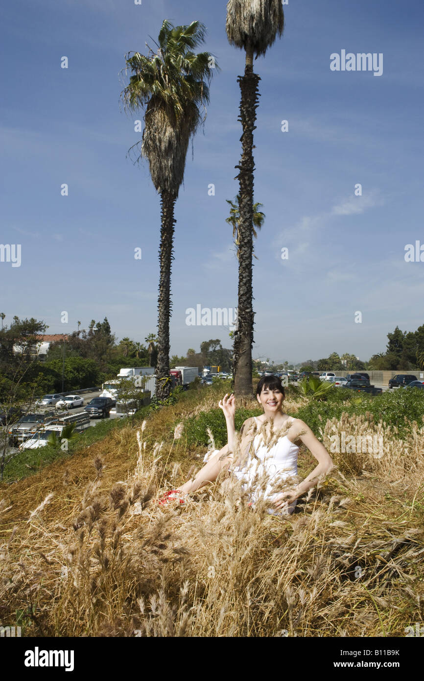 Woman performing yoga by busy freeway Stock Photo - Alamy
