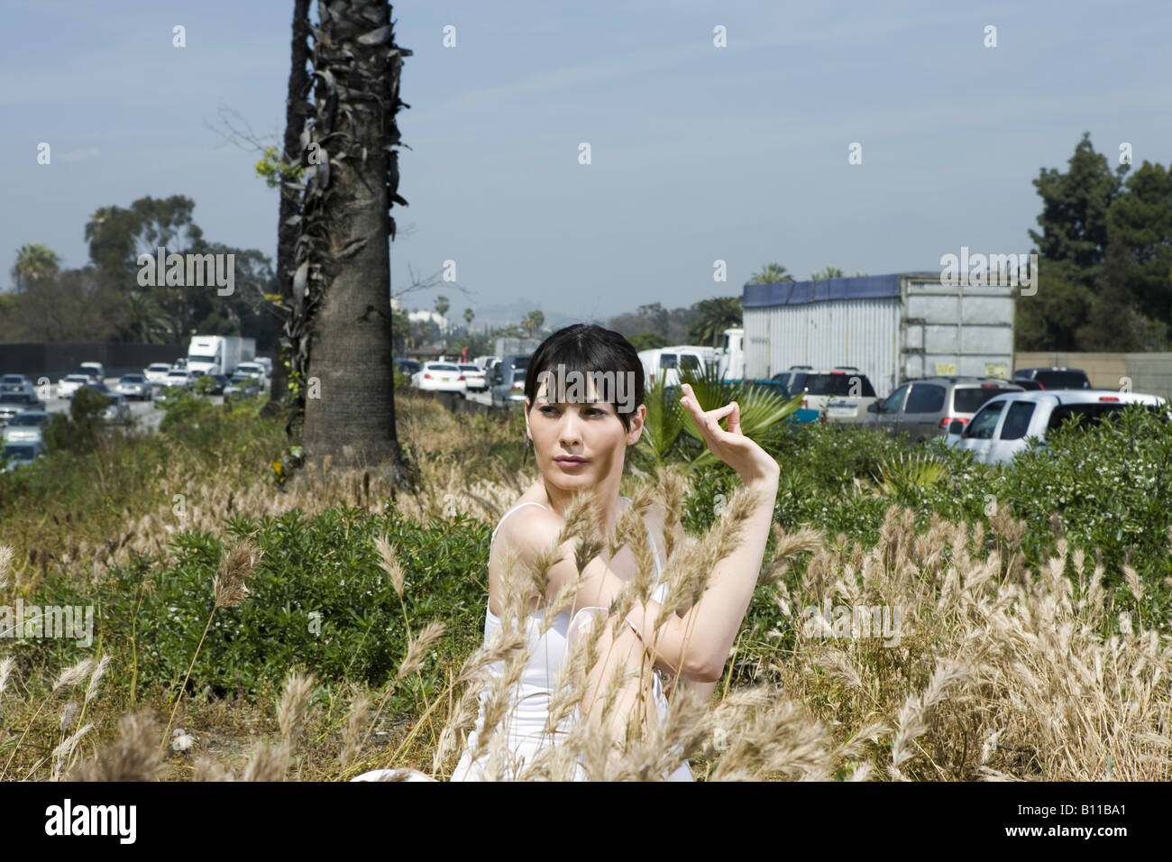 Woman performing yoga by busy freeway Stock Photo - Alamy