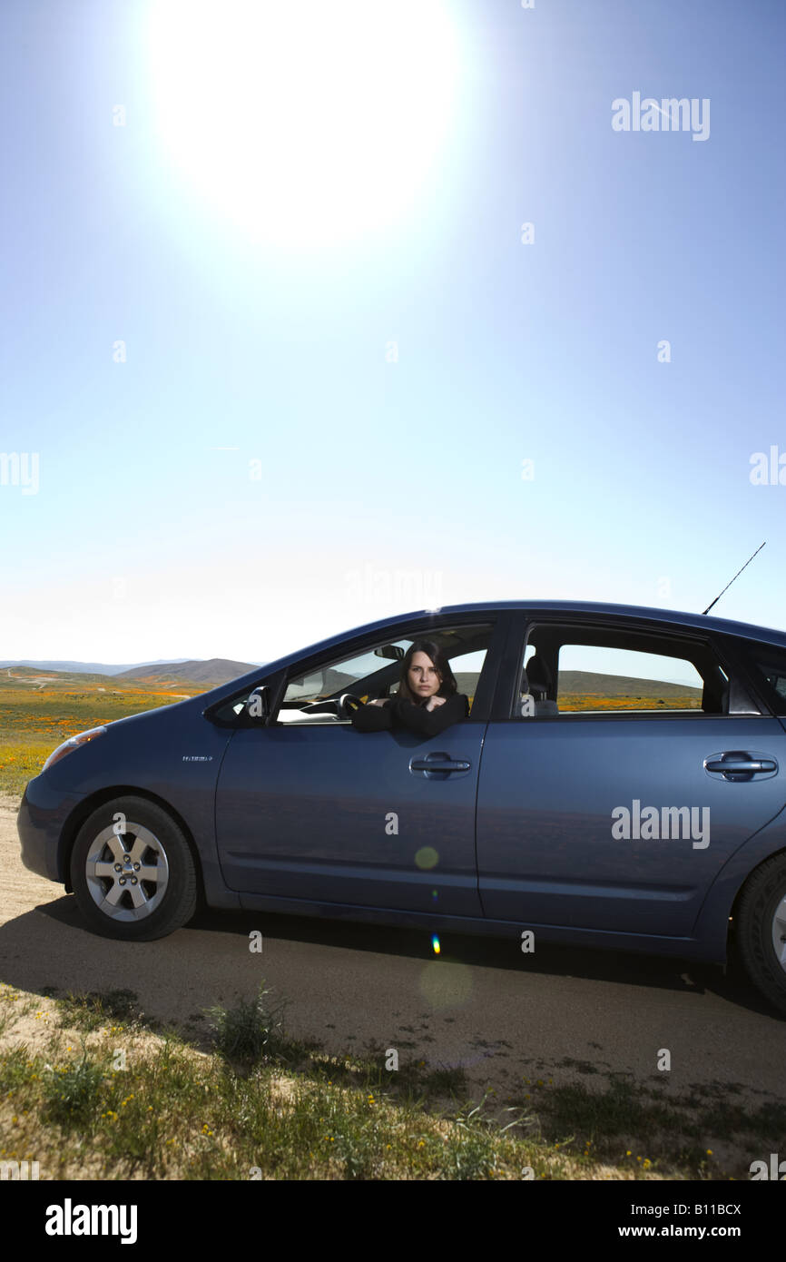 Young woman in blue Toyota Prius leaning out of open window Stock Photo ...