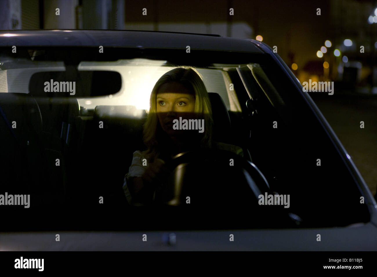 Woman views headlights through rear view mirror at night Stock Photo ... Woman views headlights through rear view mirror at night Stock Photo ...