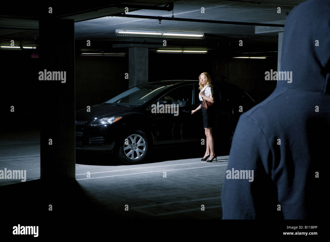 Woman sees prowler as she unlocks car in car park Stock Photo - Alamy