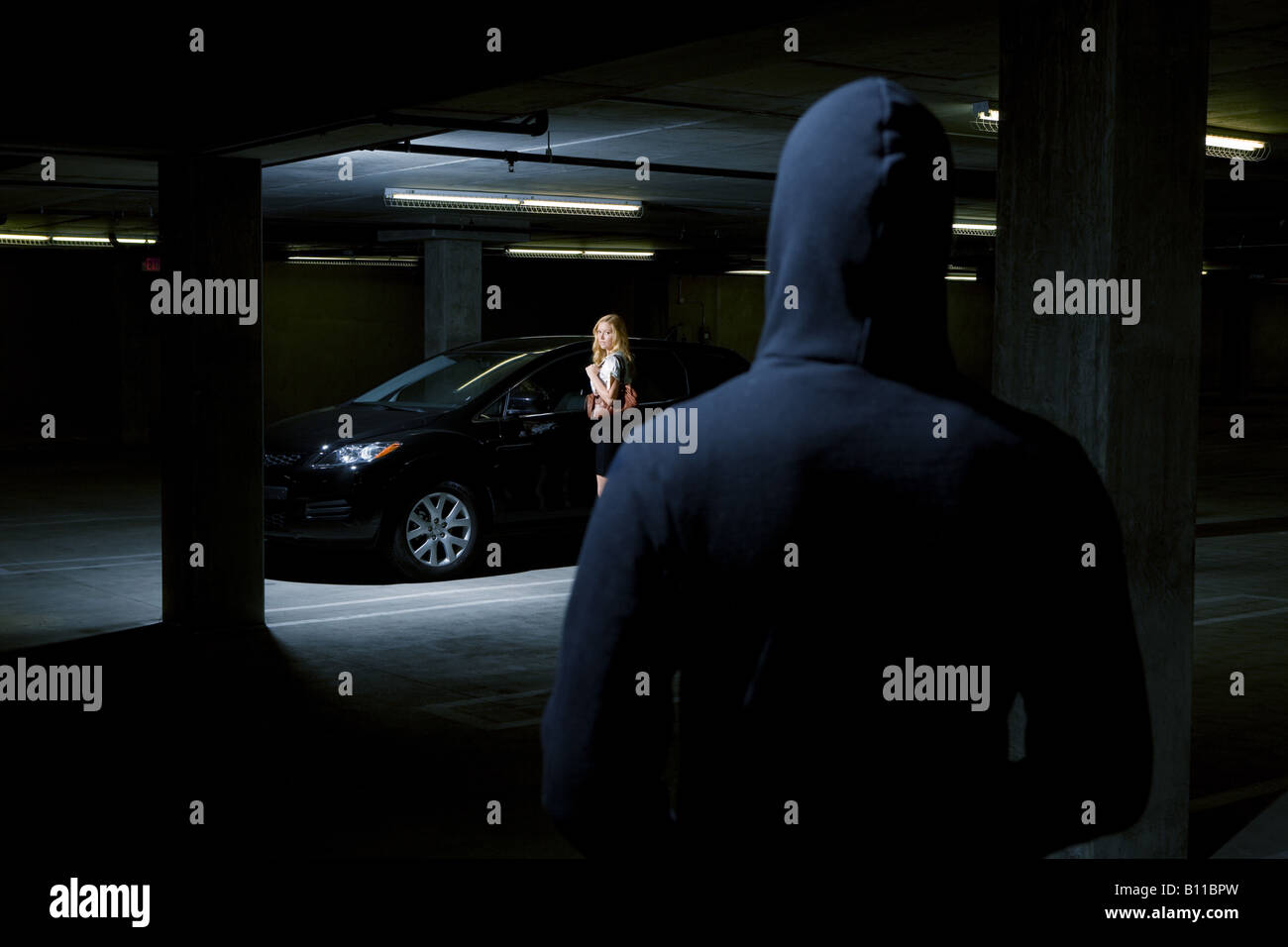 Woman sees prowler as she unlocks car in car park Stock Photo - Alamy