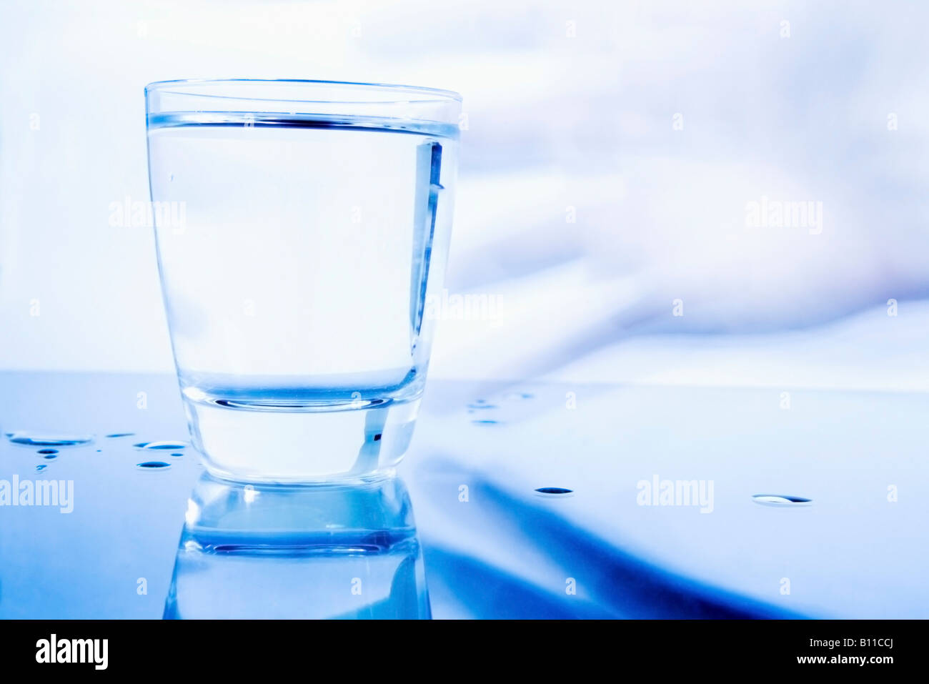 Hand grabbing a glass of water Stock Photo - Alamy