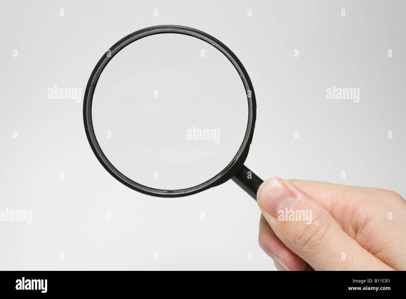 Magnifying glass in hand over white background Stock Photo - Alamy