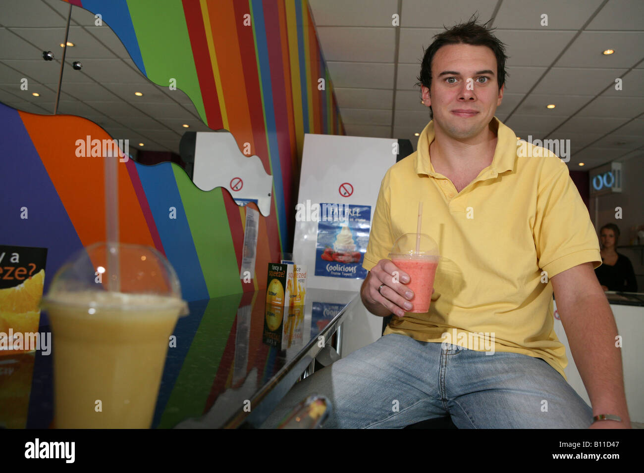 a happy male customer drinking a fruit smoothie in a smoothie bar Stock ...