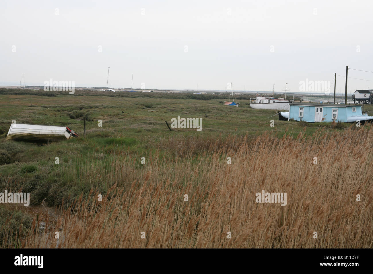 a landscape of a estery and mooring in mersea, essex with a house boat ...