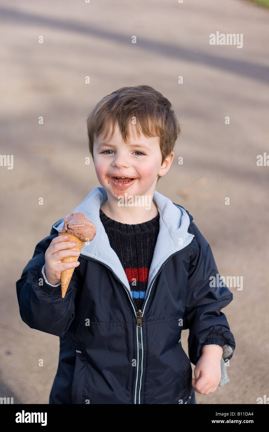 Small boy holding ice-cream with messy face outdoors Stock Photo - Alamy