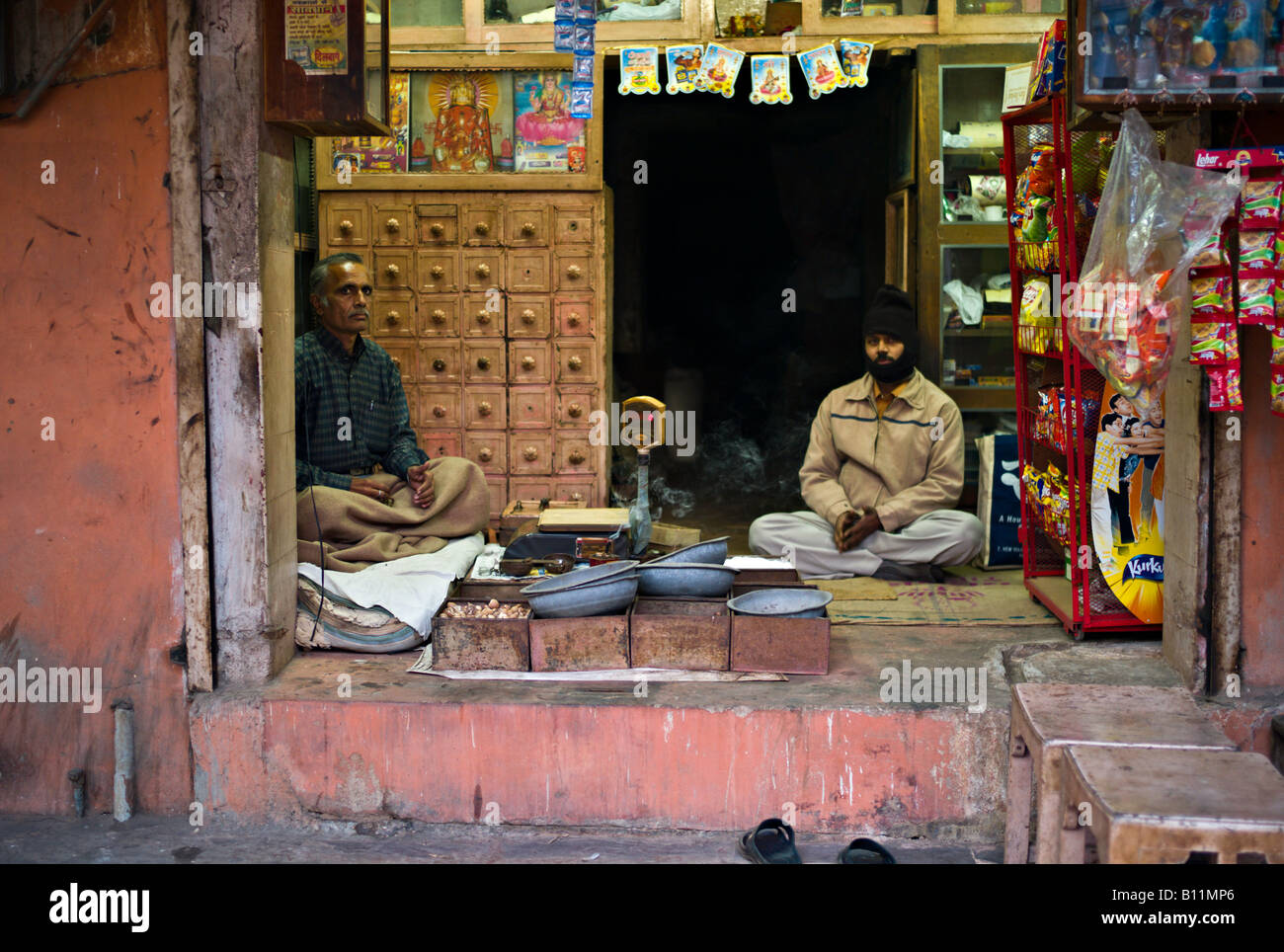 INDIA RAJASTHAN JAIPUR Father and son sit on the floor of their small ...