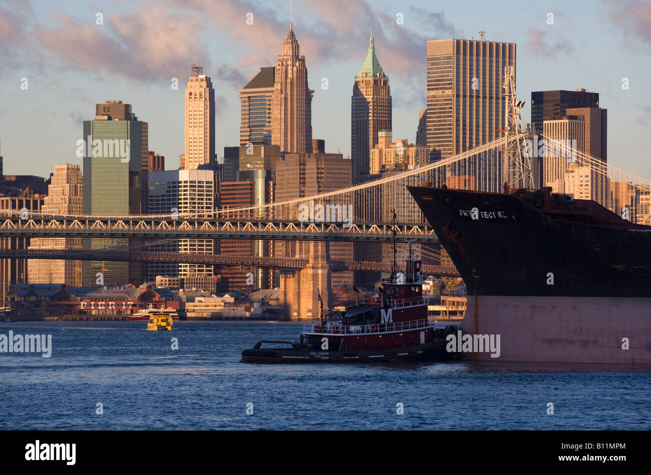 TUGBOAT PUSHING SHIP EAST RIVER DOWNTOWN SKYLINE MANHATTAN NEW YORK ...