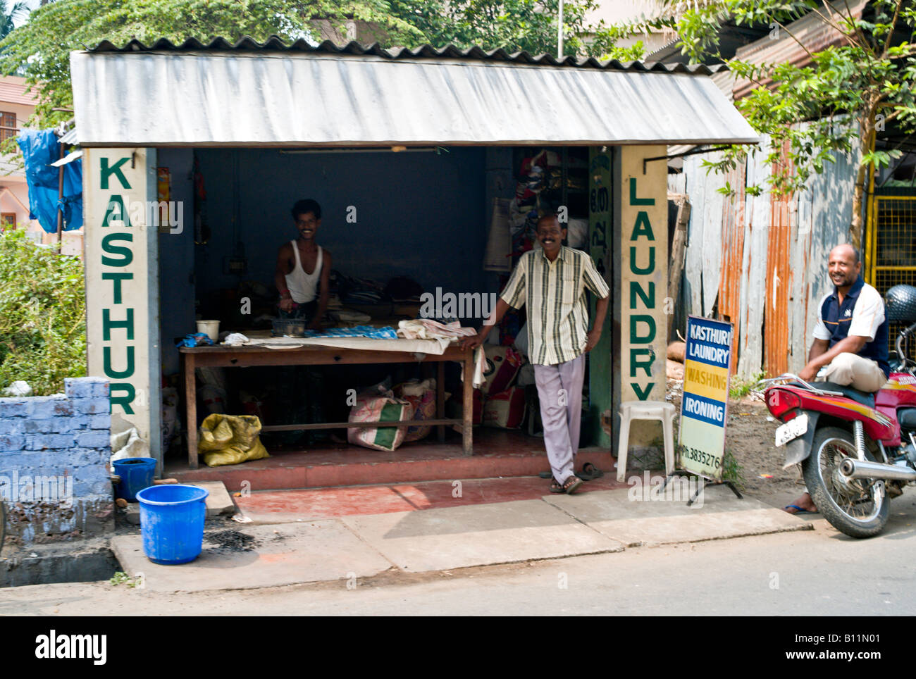 INDIA KERALA KOCHI Tiny laundry shop in a shack on a dirt street in the ...