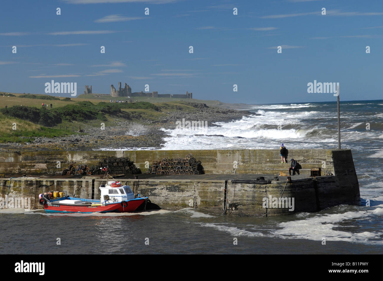 Craster harbour and Dunstanburgh Castle Northumberland England UK Stock ...