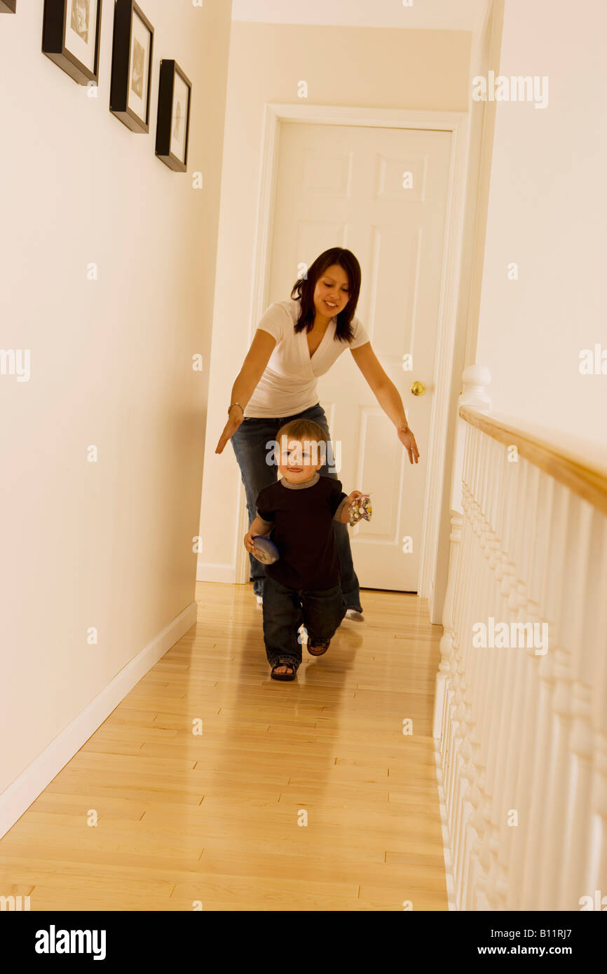 Mother chasing son down the hallway Stock Photo - Alamy