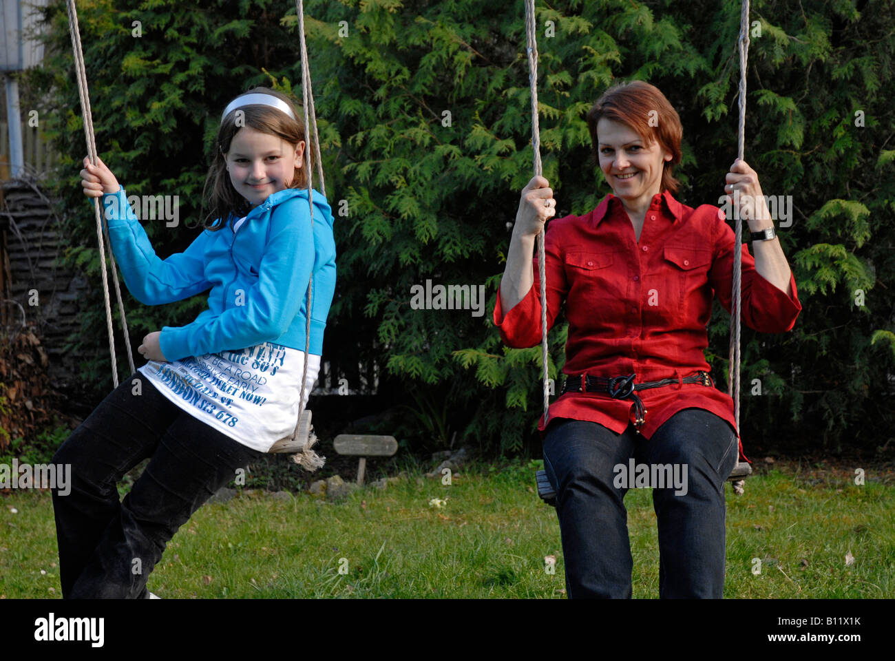 Mother and child sitting on swings Stock Photo - Alamy