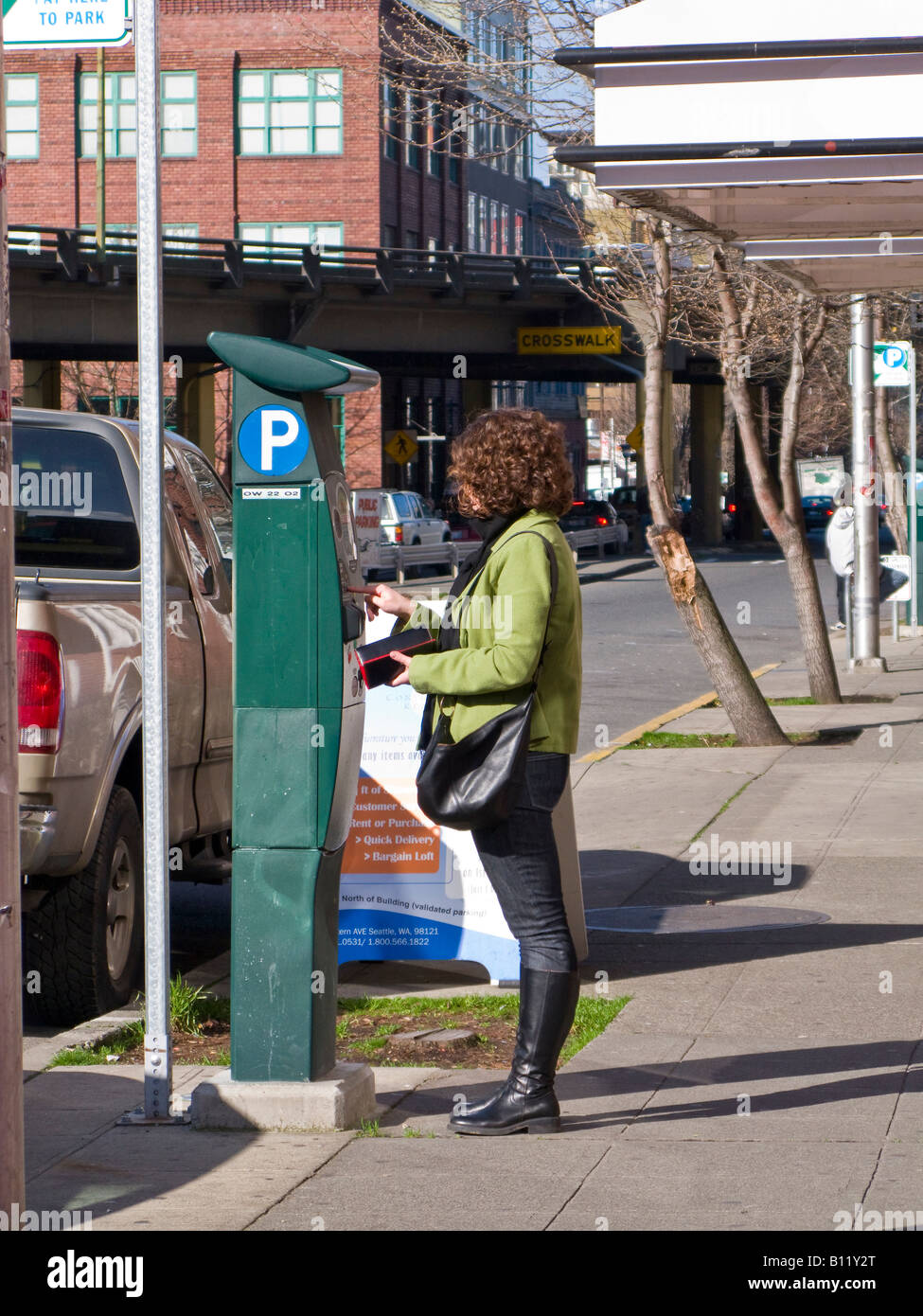 Woman pays for street parking for car at solar powerd wireless parking ...