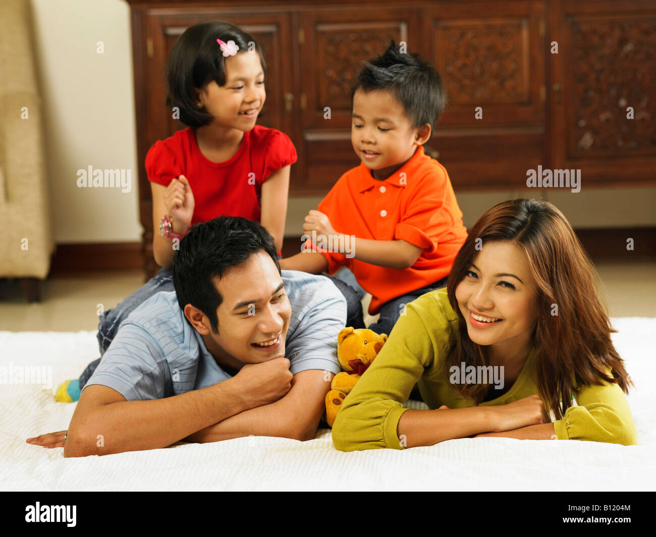 Two children seating on parent back Stock Photo - Alamy